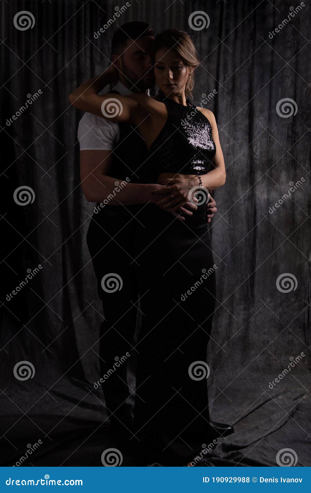 A Woman With A Light Hairstyle In A Black Dress And A Handsome Stylish