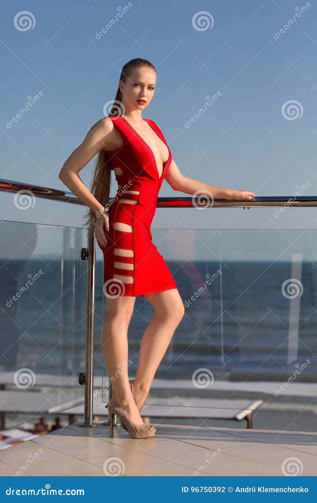 A Woman In A Stunning Red Dress And High Heels On A Hotel`s Balcony On