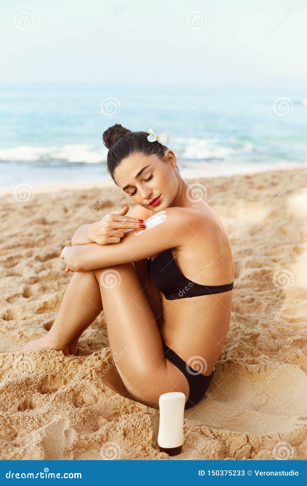 Young Woman In Bikini Applying Sun Cream On Tanned Shoulder Sun