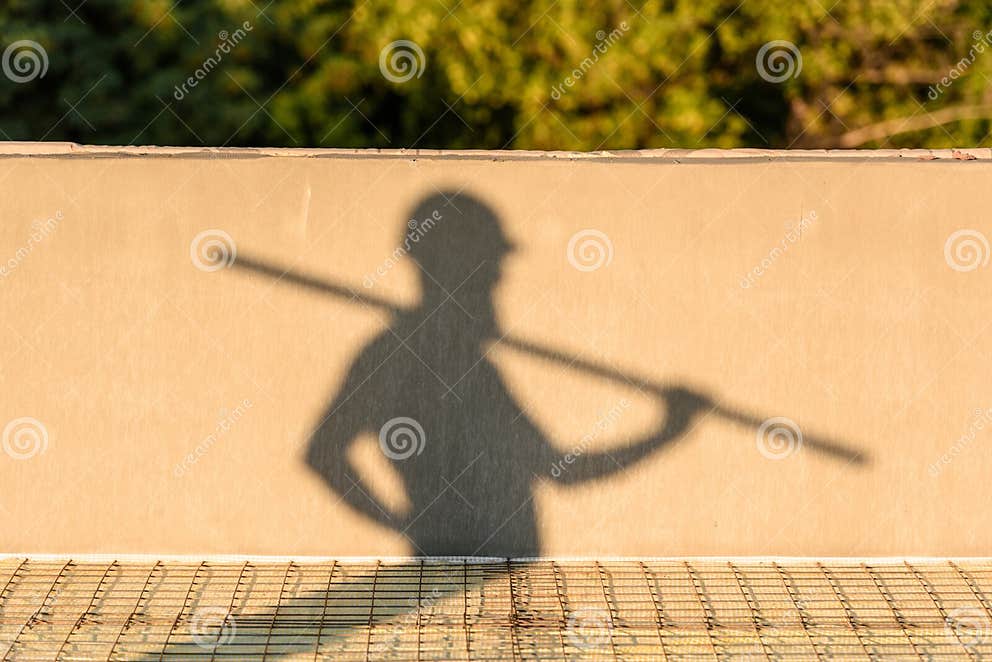 Shadow of Builder in Protective Helmet Carrying Metal Structure at ...