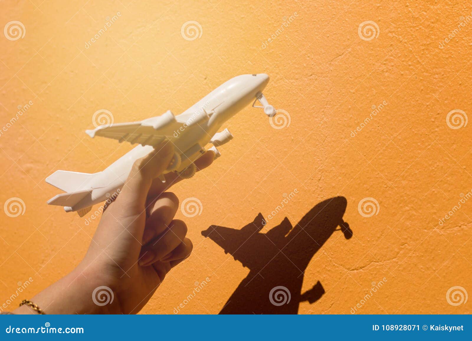 Shadow of Hand Holding Airplane Model on Orange Wall Background Stock ...