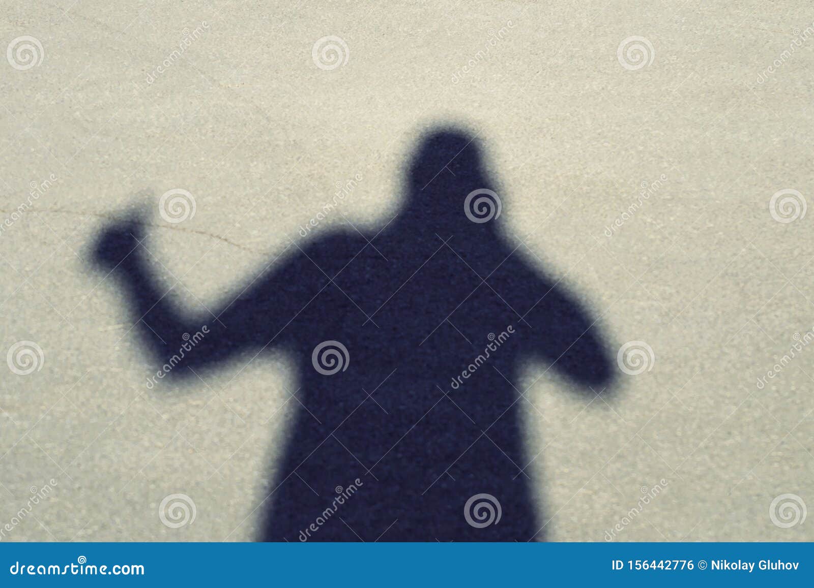 Shadow of a Man on the Pavement with a Camera in His Hands and Shows a ...