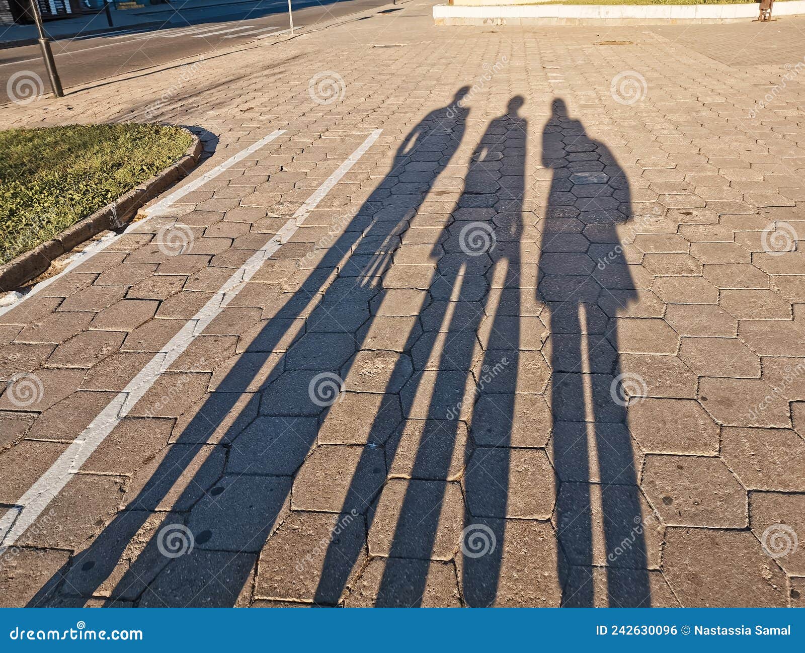 Shadows of Three People in Coats on Cobble-stone Pavement Stock Photo ...