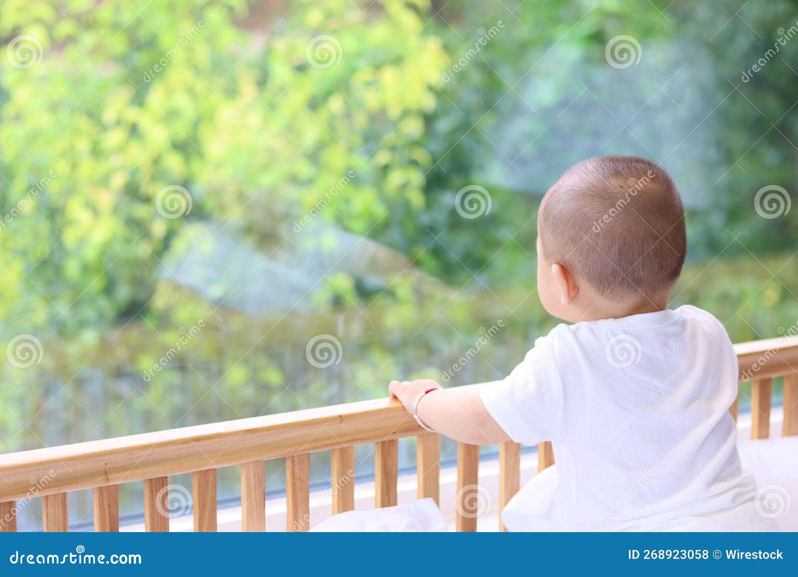 Shallow Focus Shot of a Baby Inside a Crib and Looking Out the Window ...