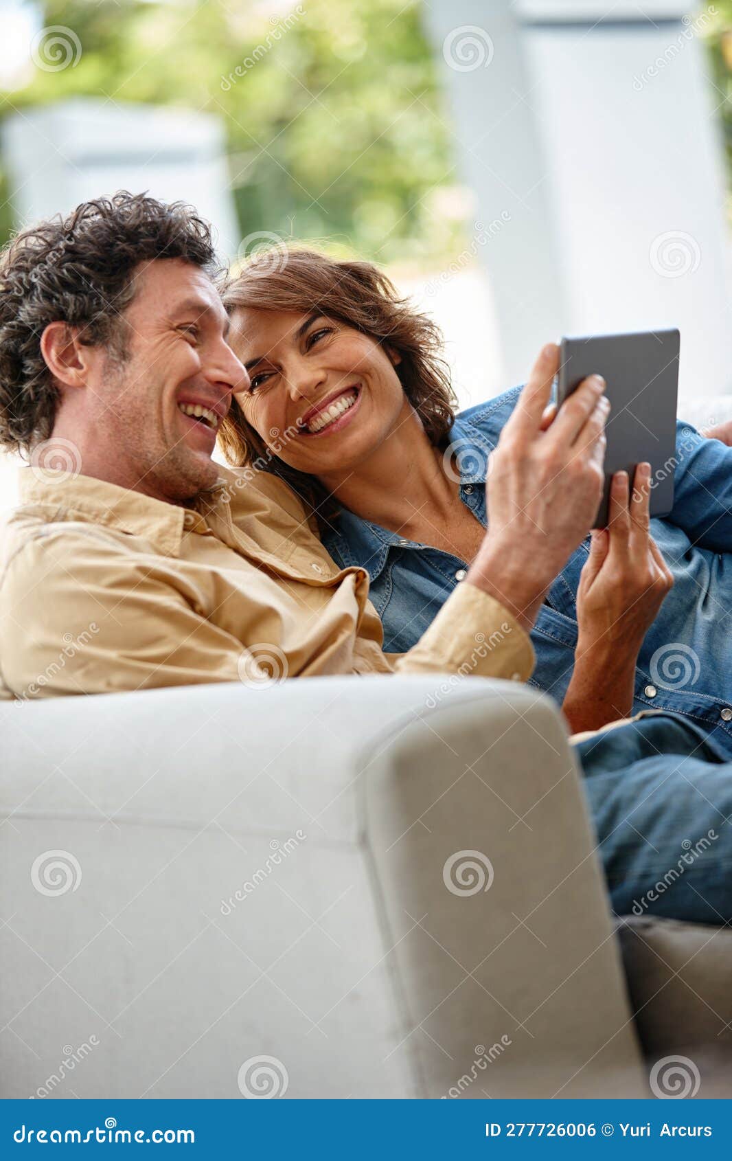 Sharing is Caring. a Husband and Wife Using a Digital Tablet Together ...