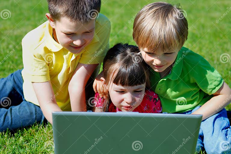 Sharing a computer stock photo. Image of boys, three, meadow - 2486708
