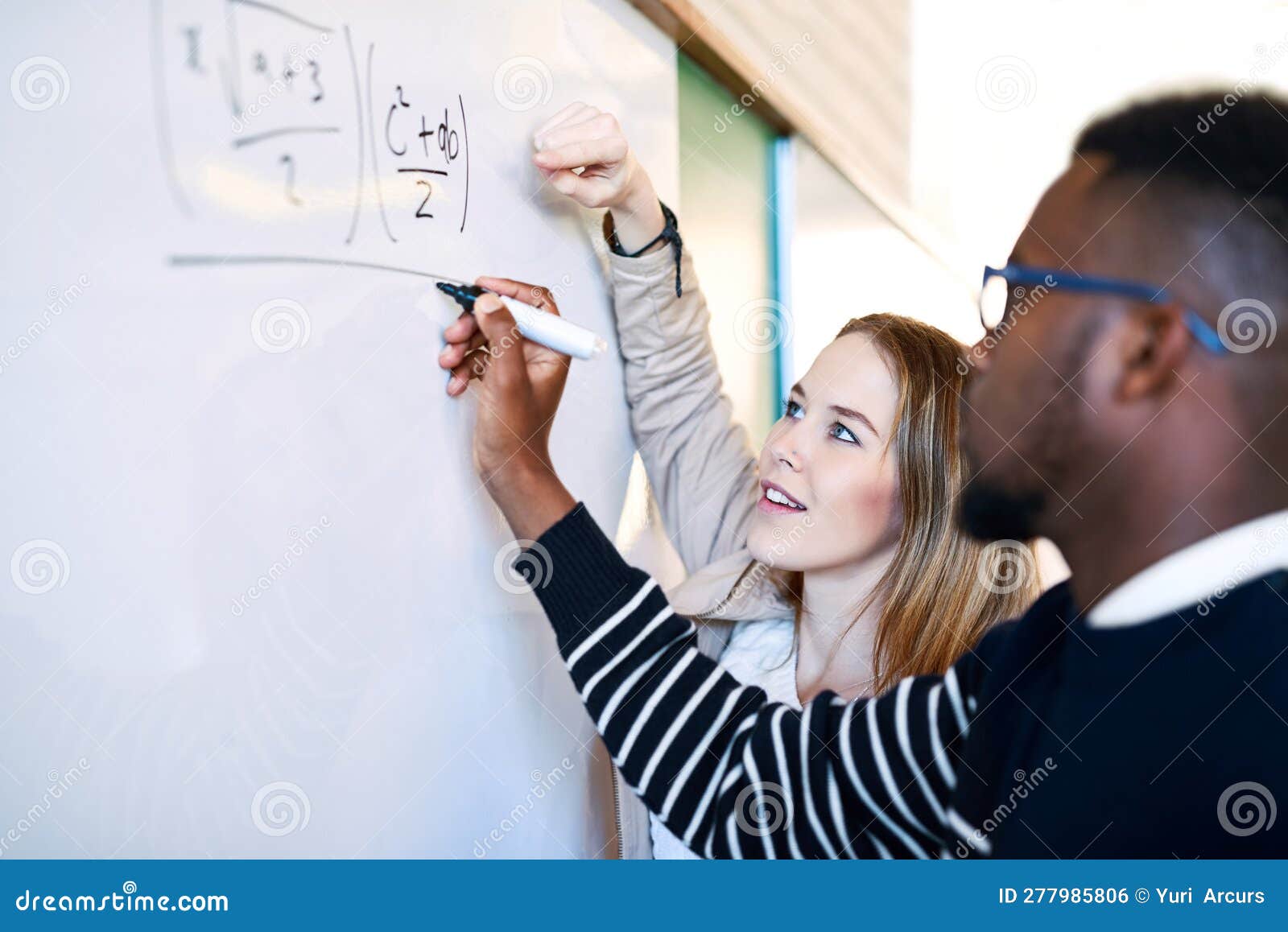 Sharing an Important Technique. a Young Man Writing on a Whiteboard while Students Look on ...
