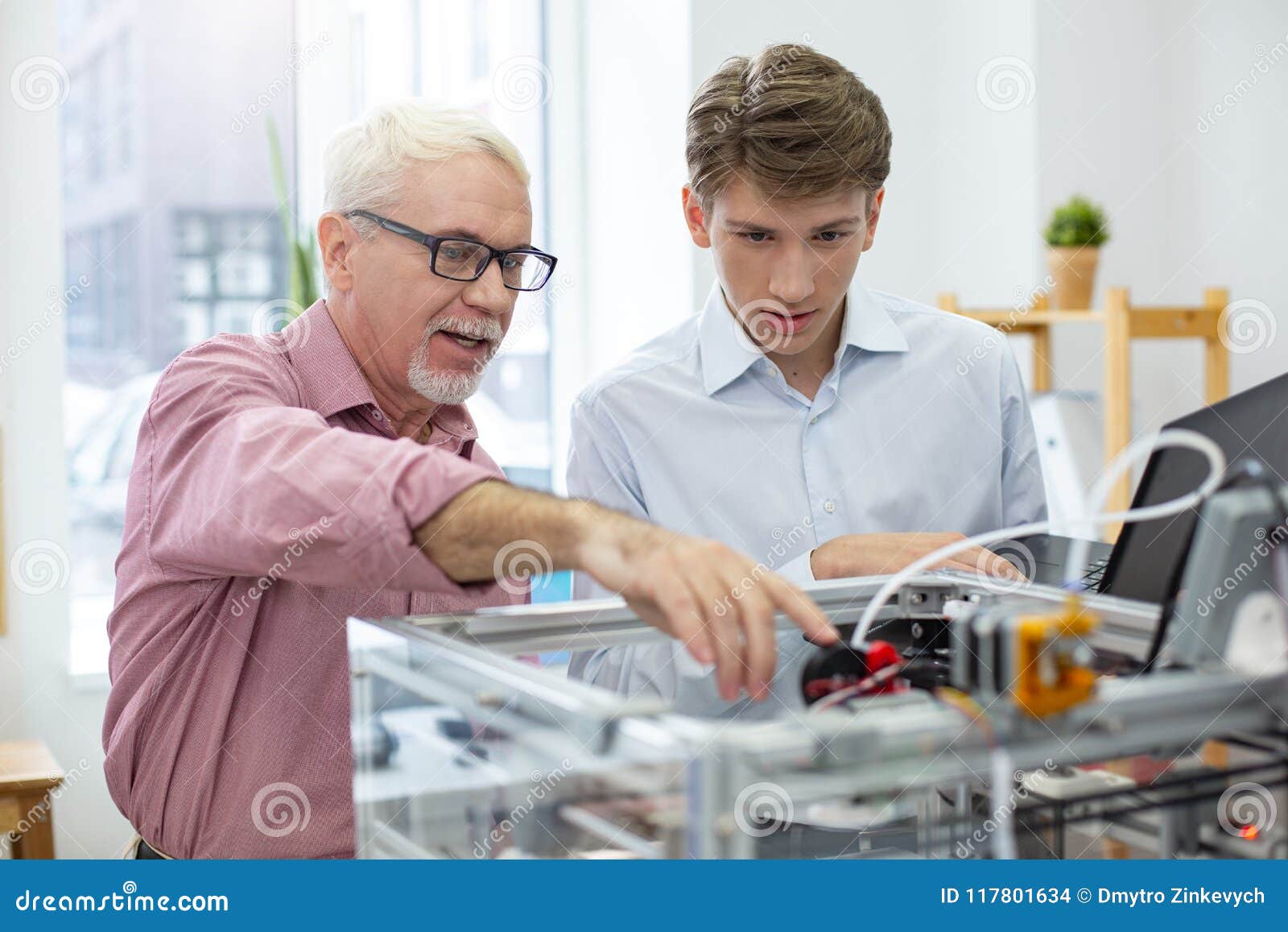 Experienced Senior Engineer Instructing Intern about 3D Printers Stock ...