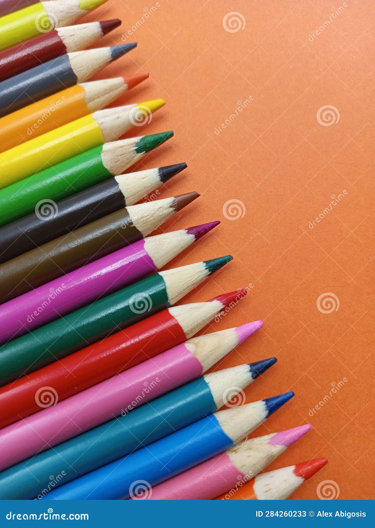 Sharp Colorful Pencil Crayons Lined Up on an Orange Background Stock ...
