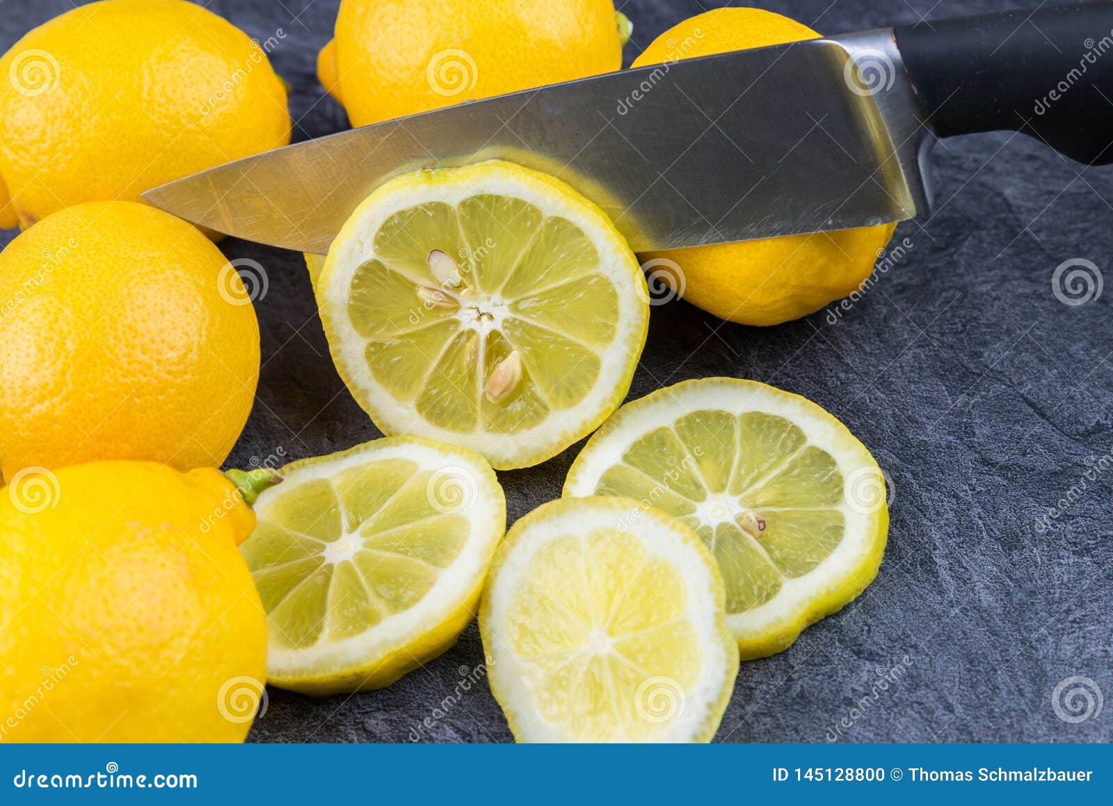 A Sharp Kitchen Knife Cuts a Lemon into Slices Stock Photo - Image of ...