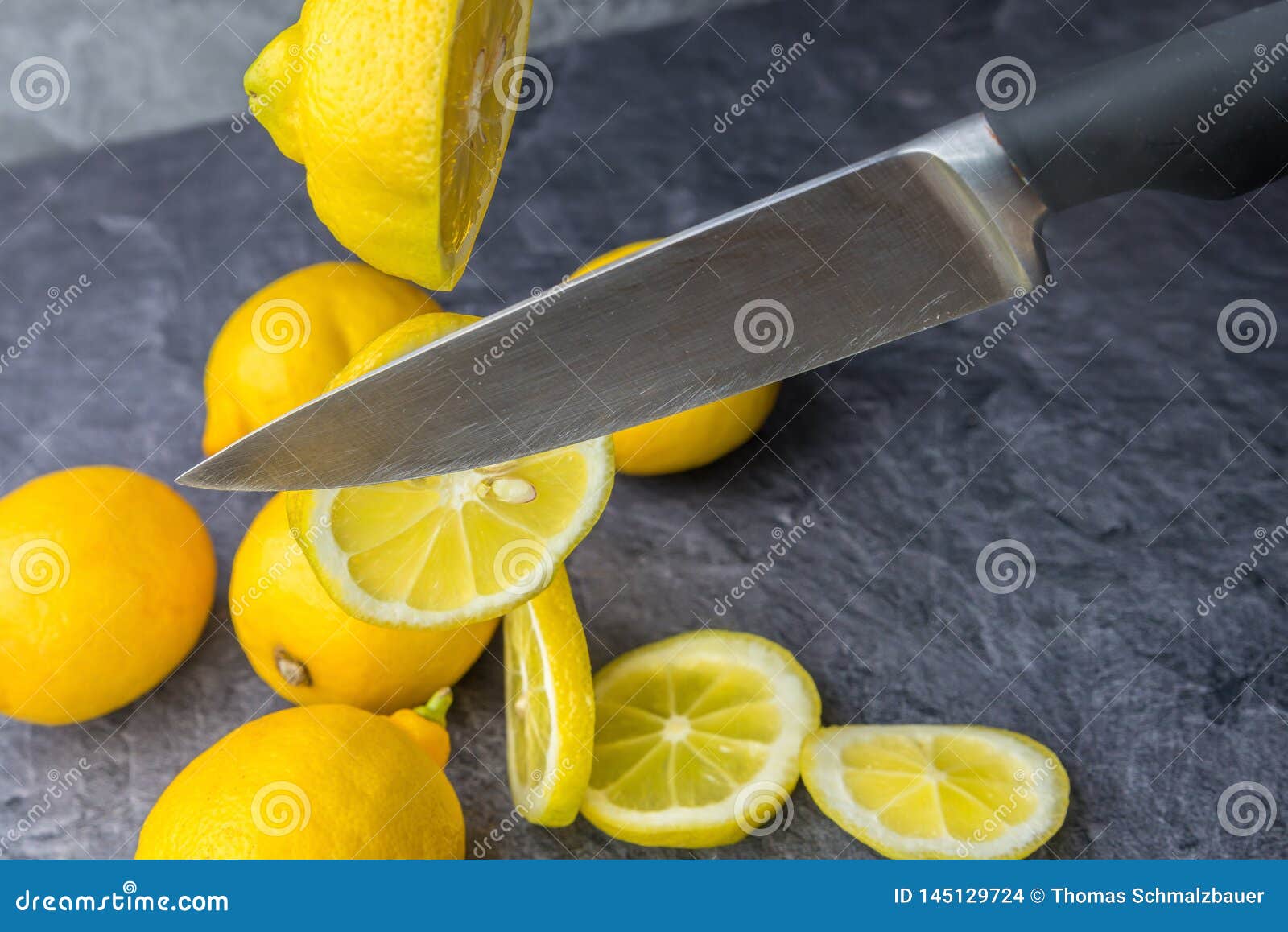 A Sharp Kitchen Knife Cuts a Lemon into Slices Stock Photo - Image of ...