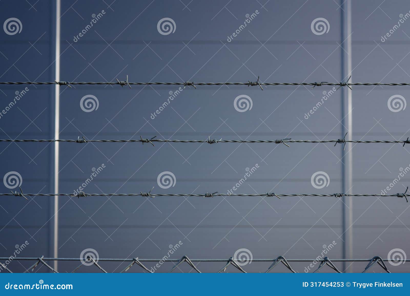 Sharp Metal Barbed Wire in Front of a Blue Warehouse.. Stock Image ...