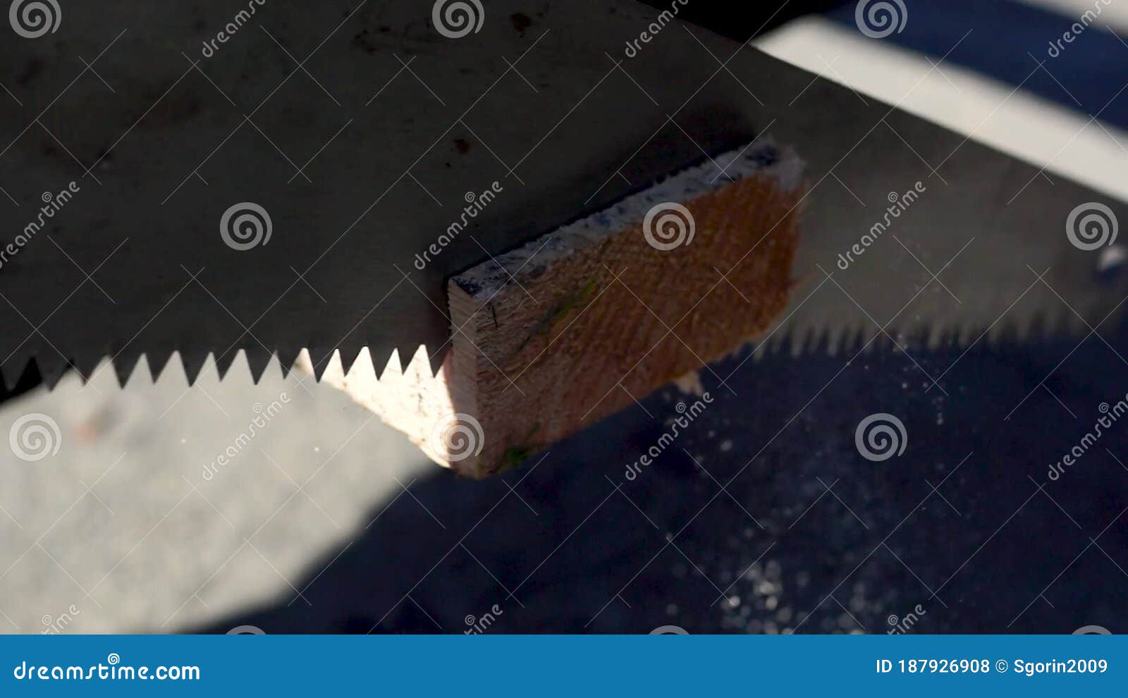 Sharp Teeth of Hacksaw are Sawing a Wooden Board at a Construction Site ...