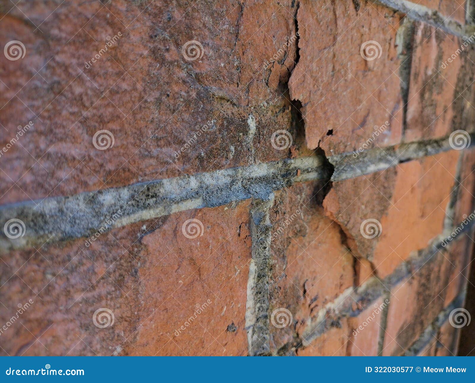 Shattered Pieces on a Red Mud Brick Wall with Deep Cracks. Damage To ...