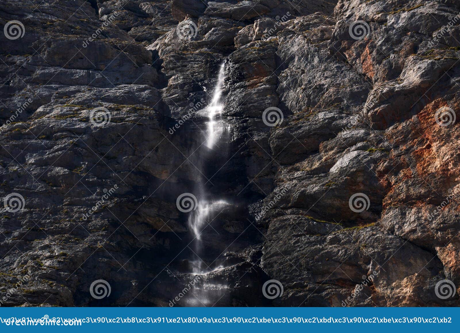 Sheer Rock Wall with a Small Waterfall Flowing Down it Stock Photo ...