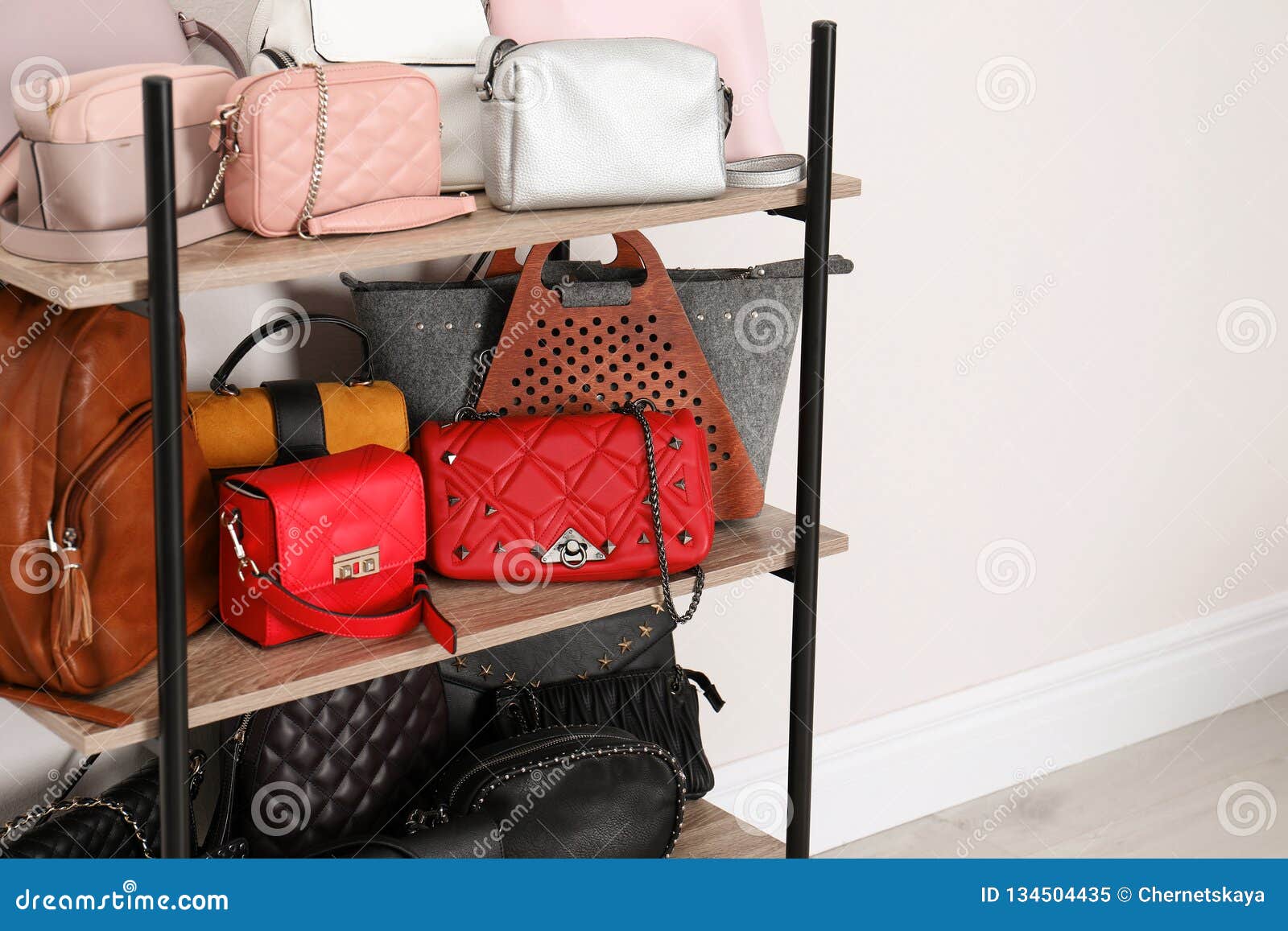 Shelving Unit with Stylish Purses Near White Wall, Space for Text ...