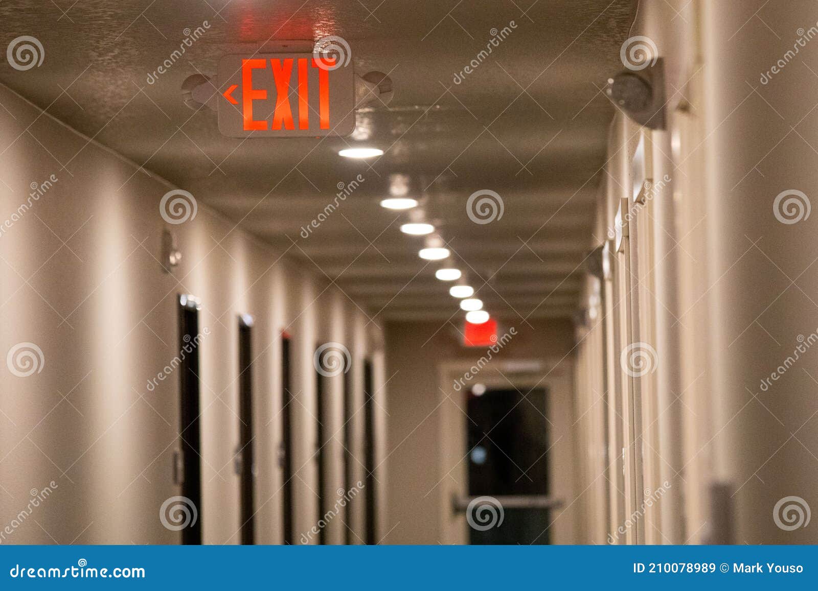 An Exit Sign in Sharp Focus with a Long Blurry Hallway. Stock Image ...