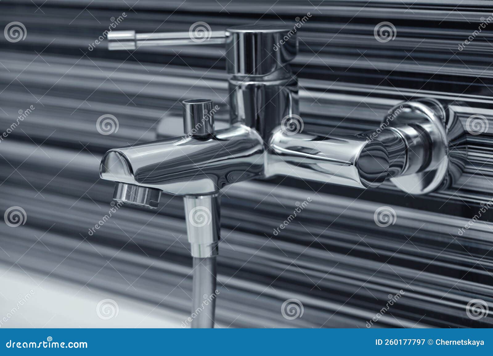 Shiny Bath Water Tap Installed On Black And White Wall Stock Image