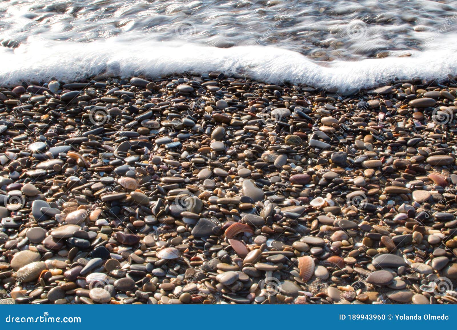 Shiny Pebbles from the Beach with a Wave on Top. Background. Textures ...