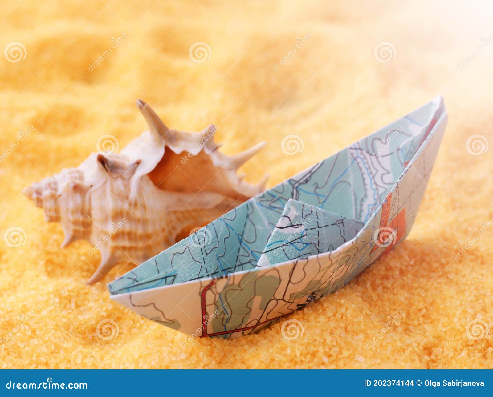 Ship Model from a Paper Map on the Sand, Seashell Stock Photo - Image ...