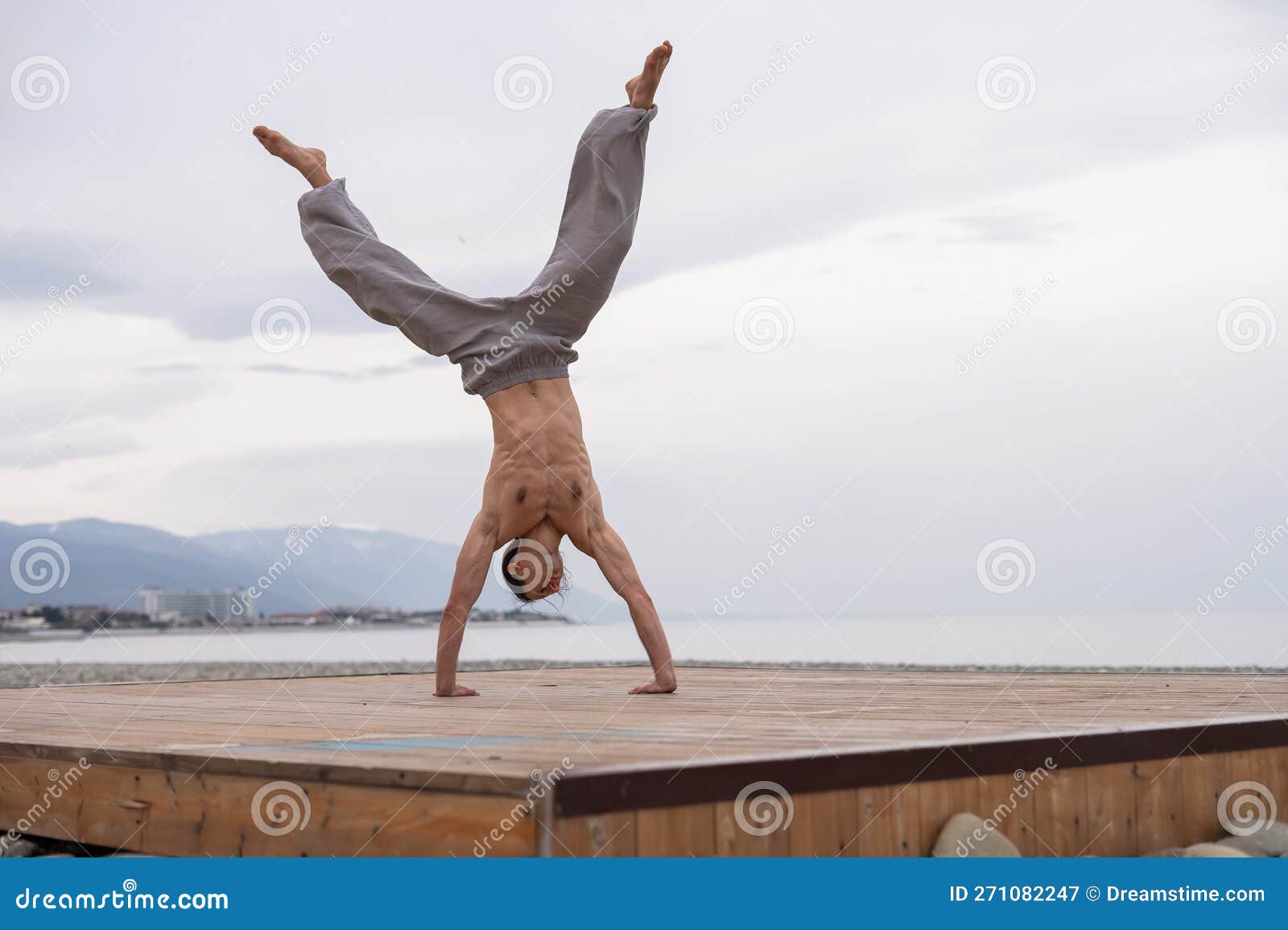 Shirtless Caucasian Man Doing Acrobatic Wheel on the Beach. Stock Image ...