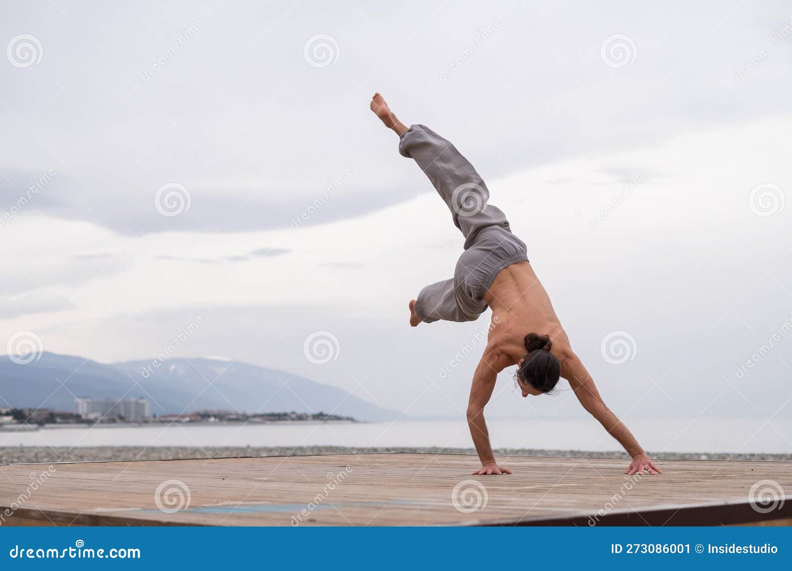 Shirtless Caucasian Man Doing Acrobatic Wheel on the Beach. Stock Image ...