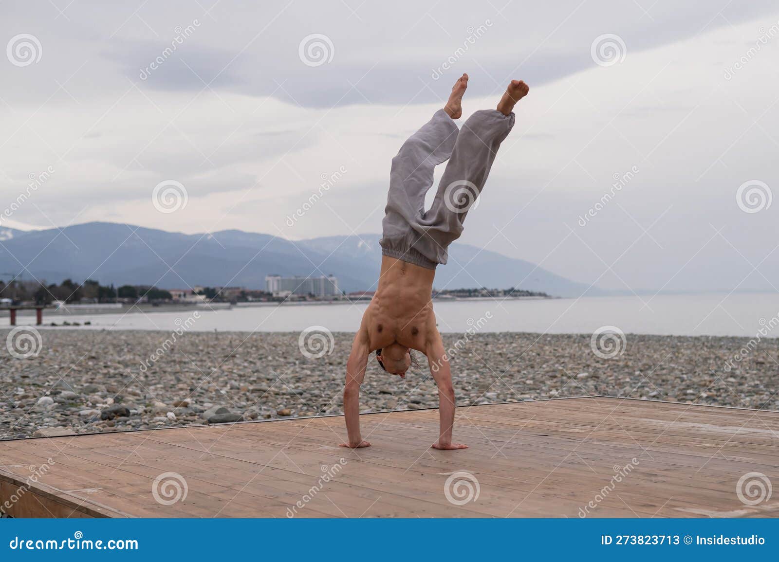 Shirtless Caucasian Man Doing Acrobatic Wheel on the Beach. Stock Image ...