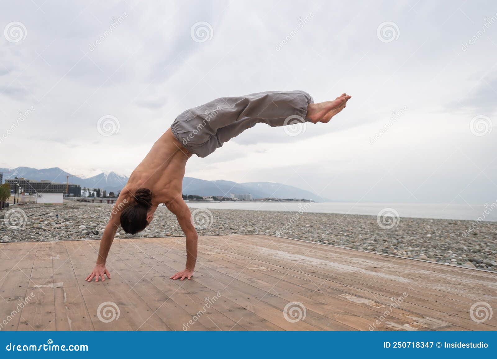 Shirtless Caucasian Man Doing Backflip on Pebble Beach. Stock Image ...