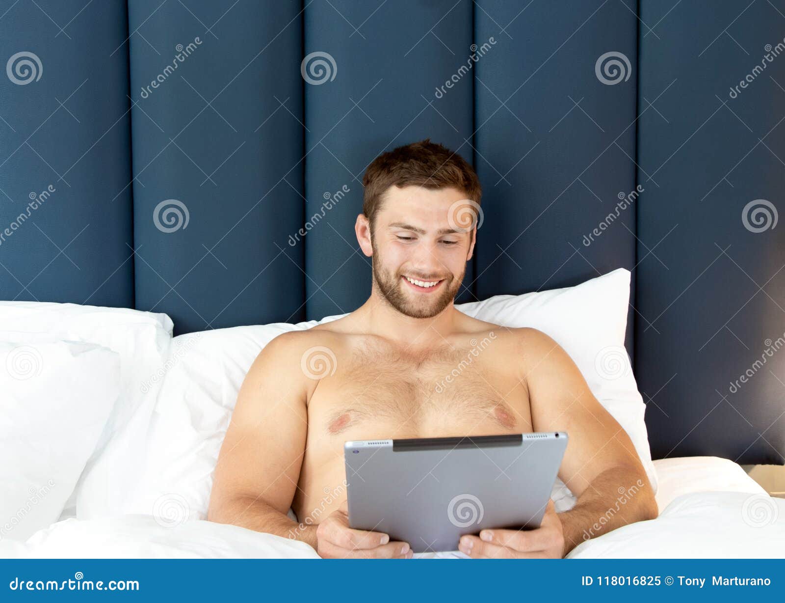 Shirtless Hunky Man With Beard Lies Naked In Bed Stock Image