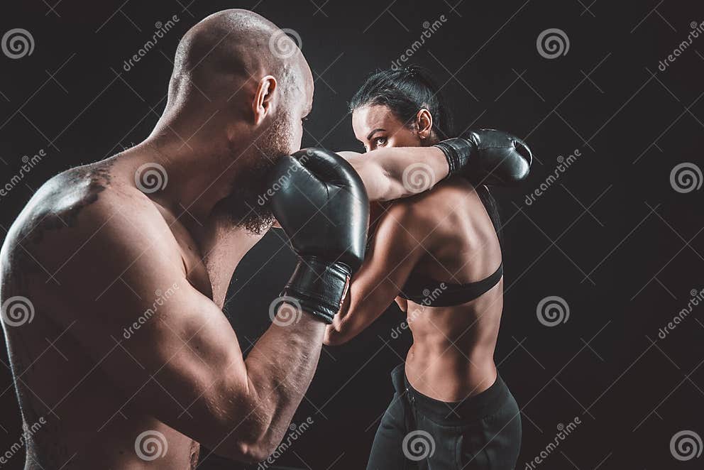 Shirtless Woman Exercising With Trainer At Boxing And Self Defen Stock