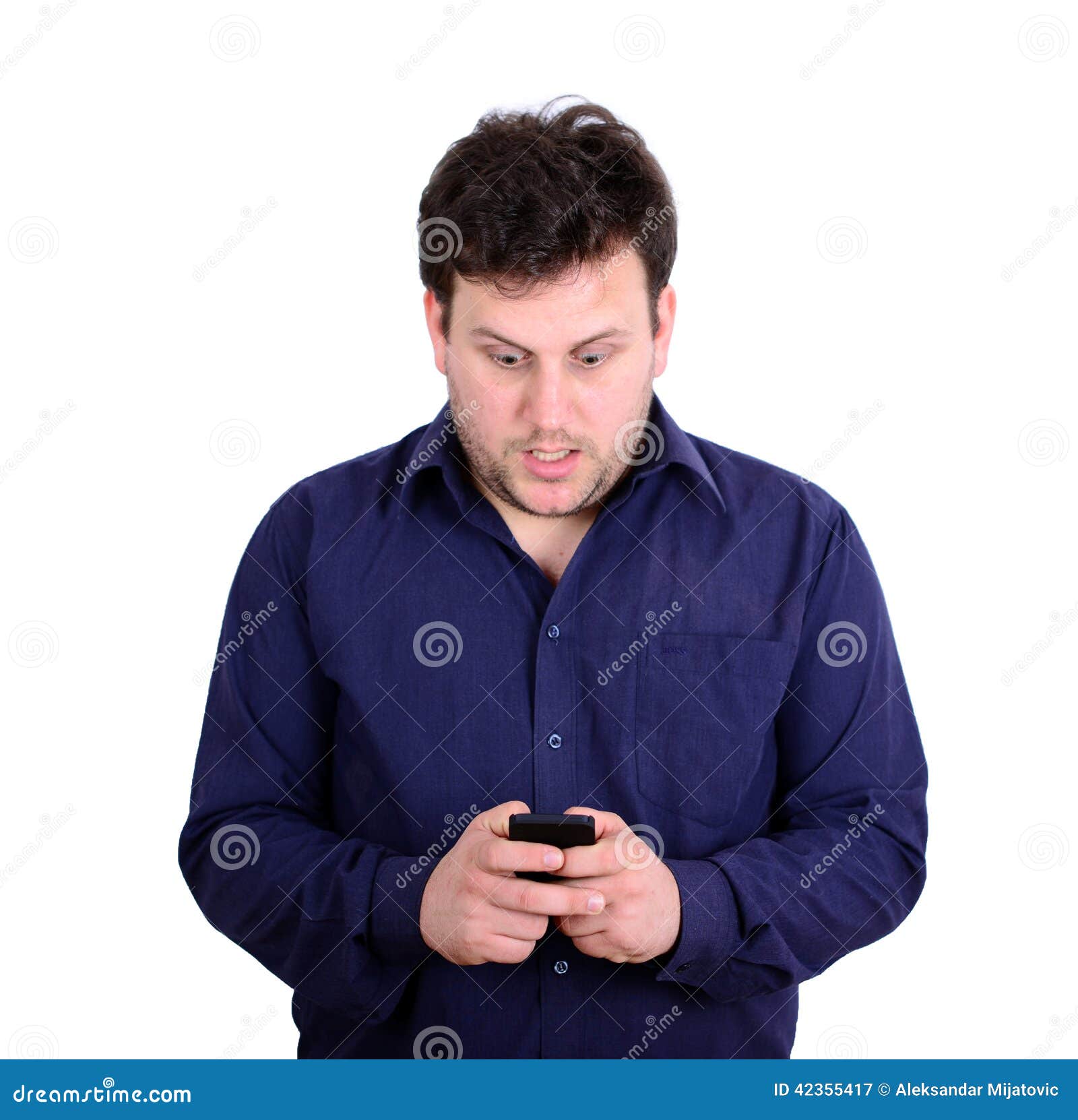 Shocked Businessman Looking At Cell Phone Against White Background