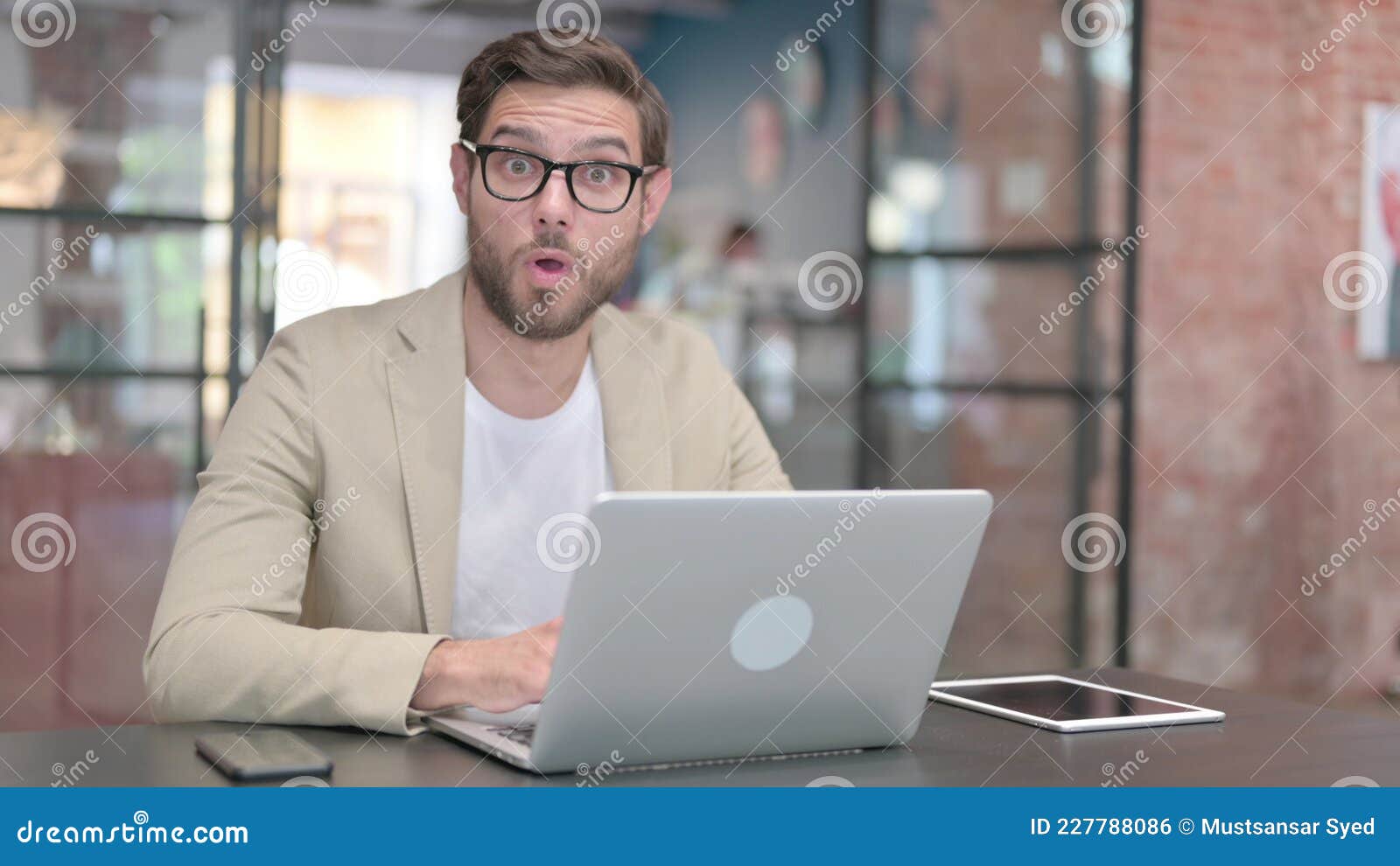Shocked Young Man Wondering at Work Stock Photo - Image of business ...