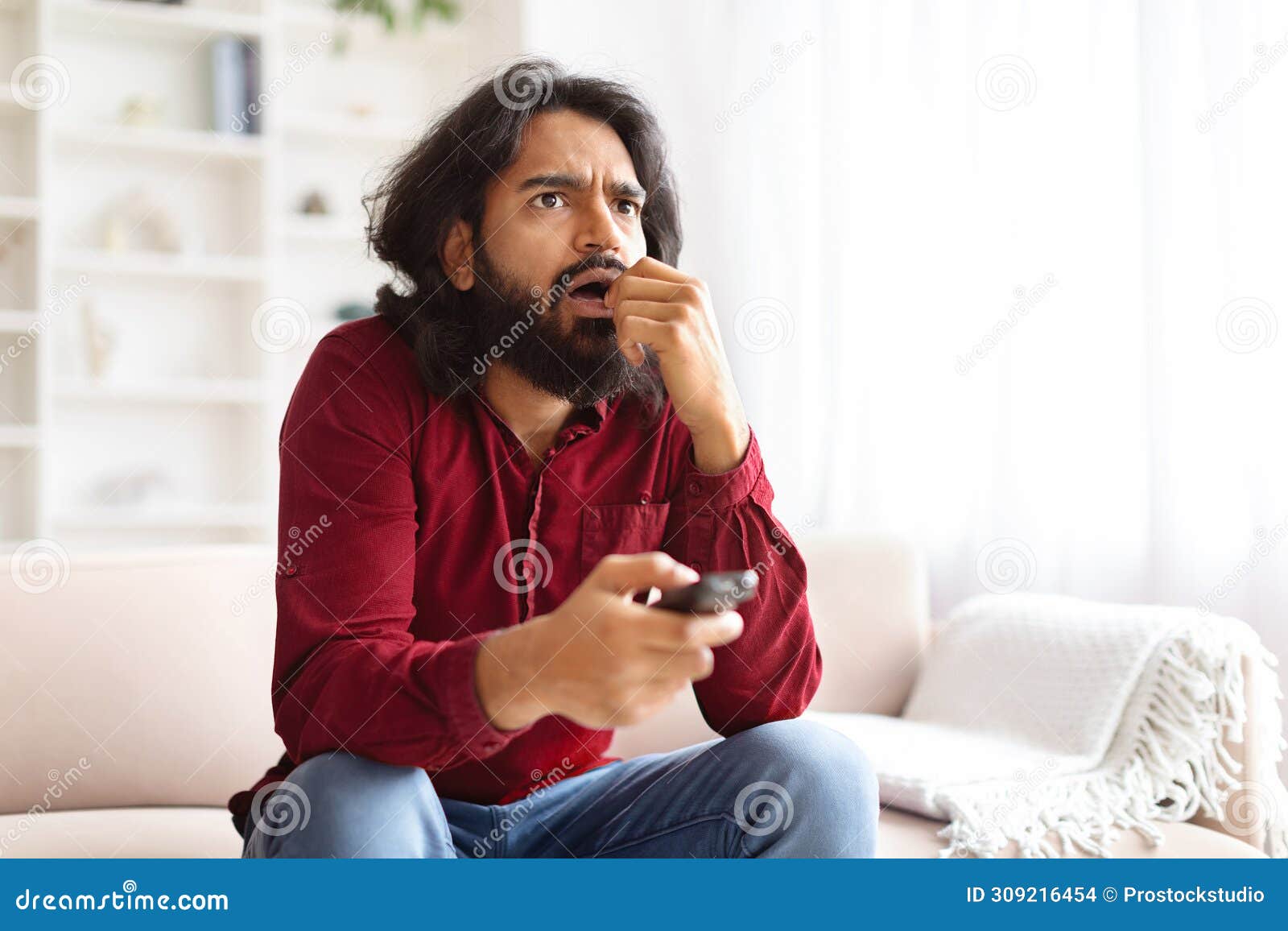Shocked Eastern Guy with Remote Control Sitting on Couch Stock Photo ...