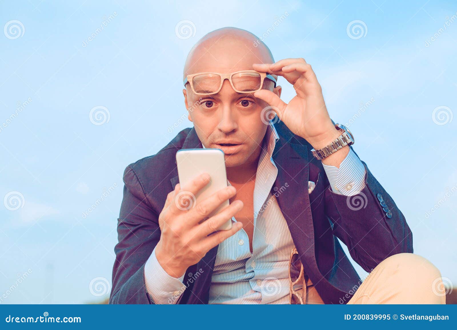 Shocked Man Looking At Phone Seeing Bad News Or Text Message Stock