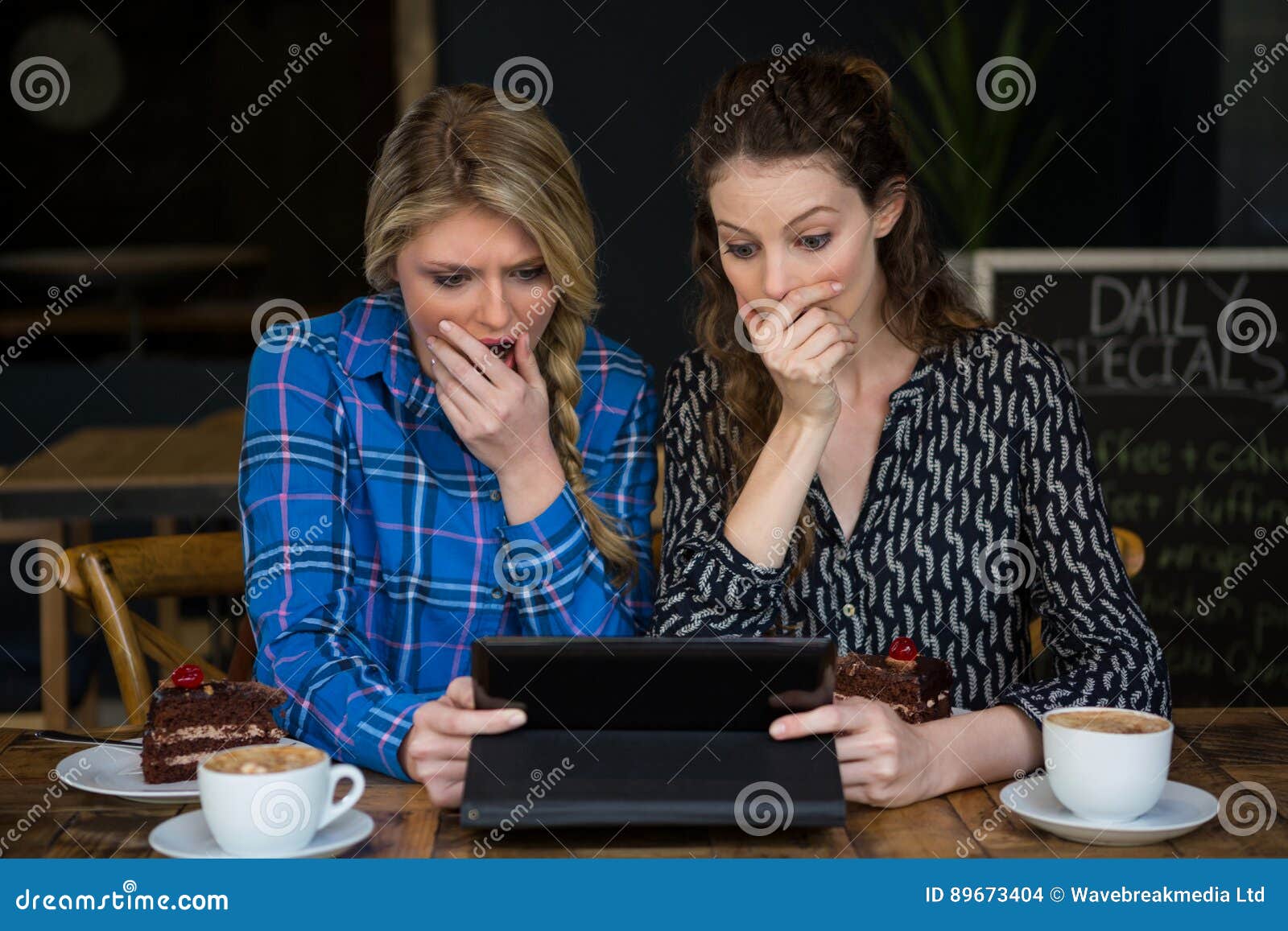 Shocked Women Using Tablet Computer in Coffee Shop Stock Photo - Image ...