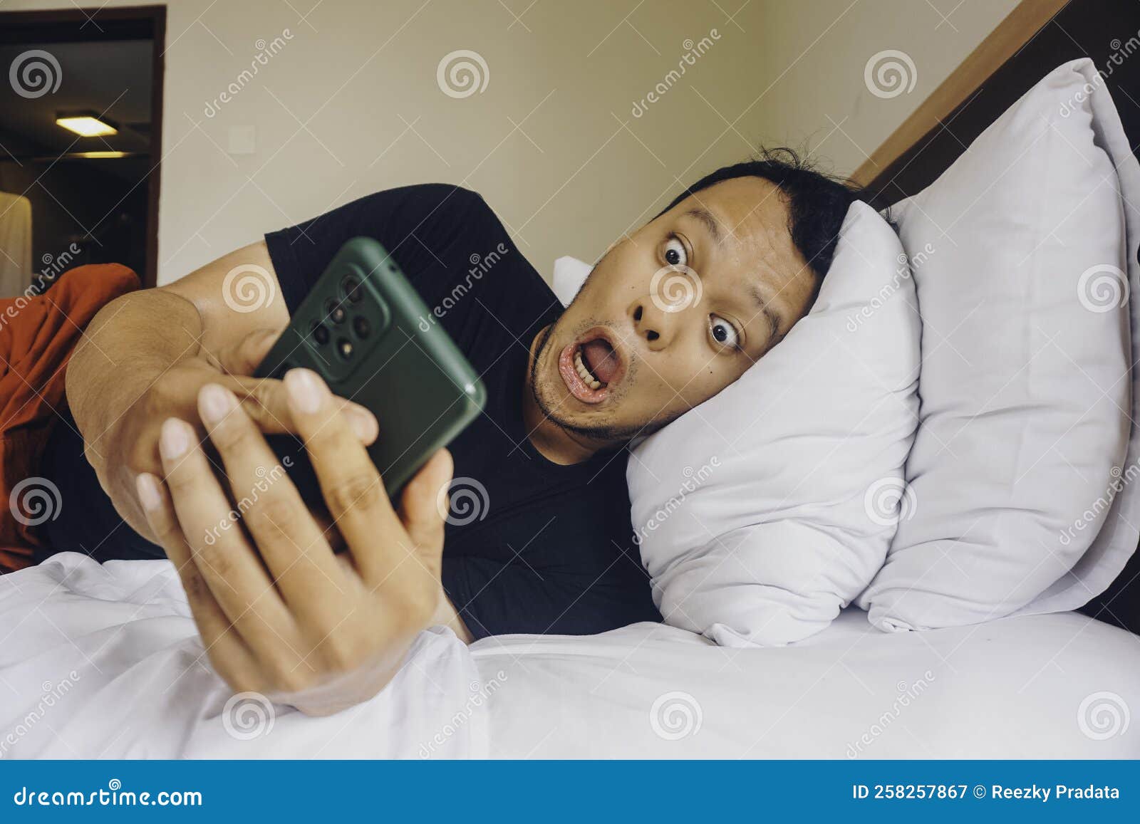 Shocked Young Man Checking on Her Phone while Lying in Bed Stock Image ...