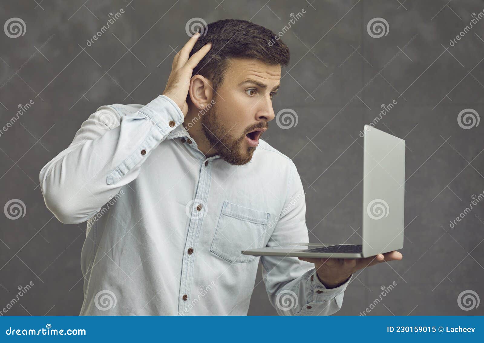 Shocked Young Man Looking at Screen of Laptop Computer that he S ...