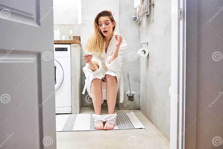 Shocked Young Woman Looking At Control Line On Pregnancy Test While