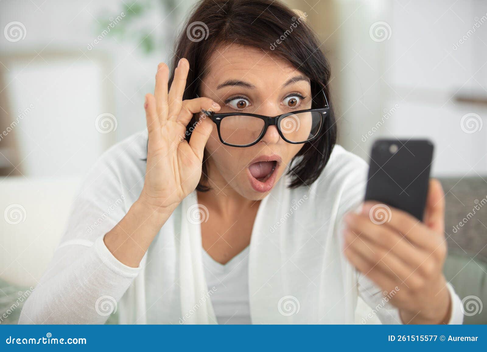 Shocked Young Woman Looking at Mobile Phone at Home Stock Image - Image ...