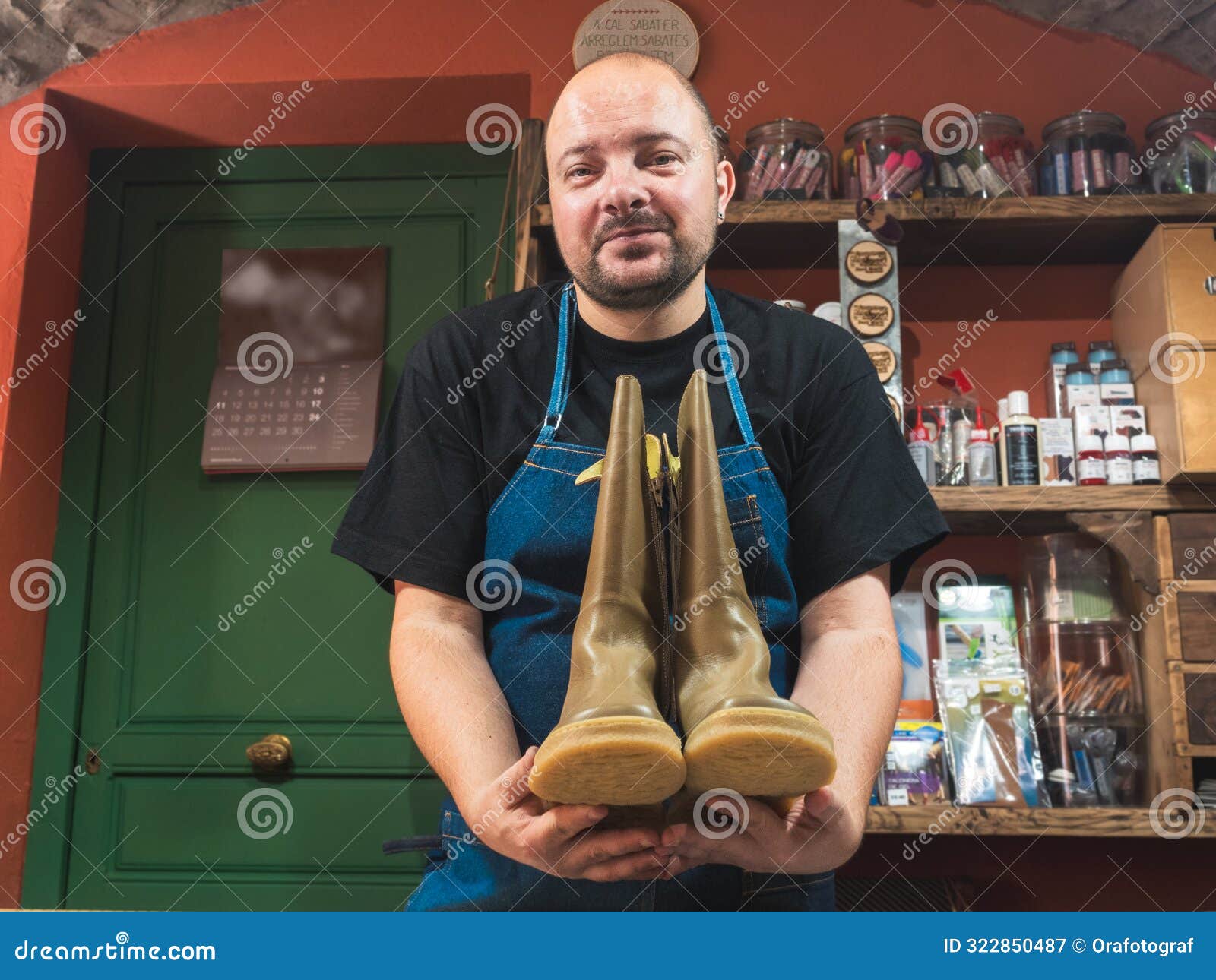 Shoemaker Man Poses Facing the Camera Showing a Pair of Boots Stock ...