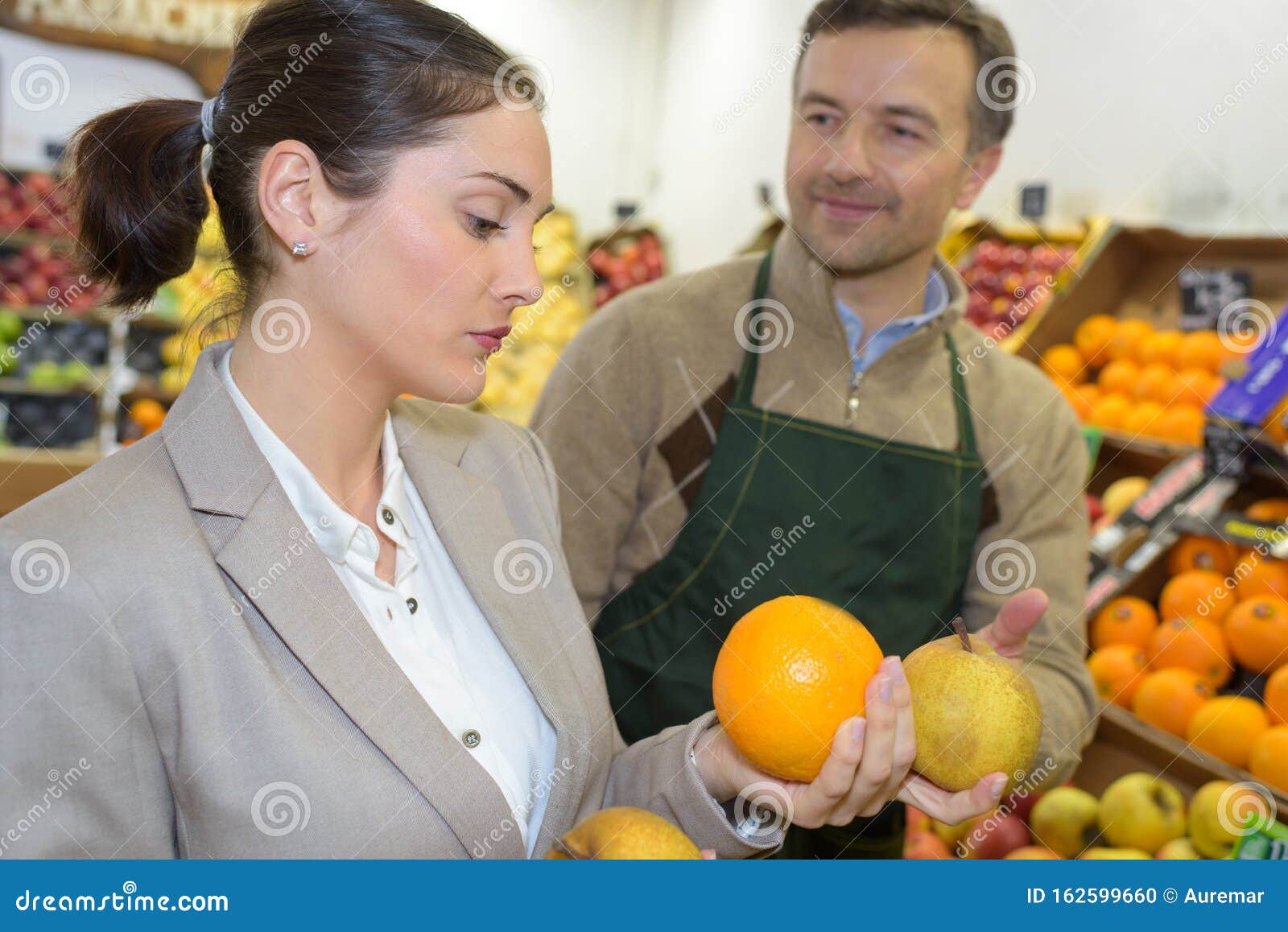 Shop Assistant Passing Grapefruit To Customer Stock Photo - Image of ...