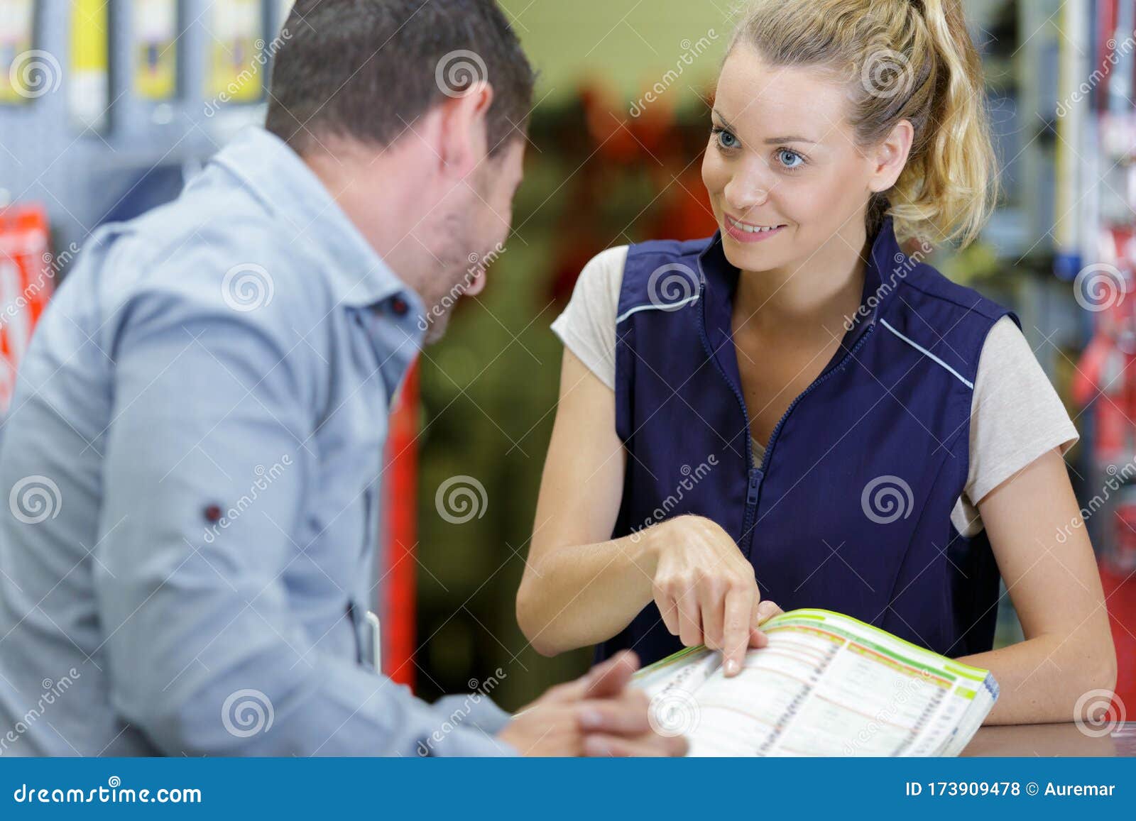 Shop Assistant Showing Catalogue Reference To Customer Stock Photo ...