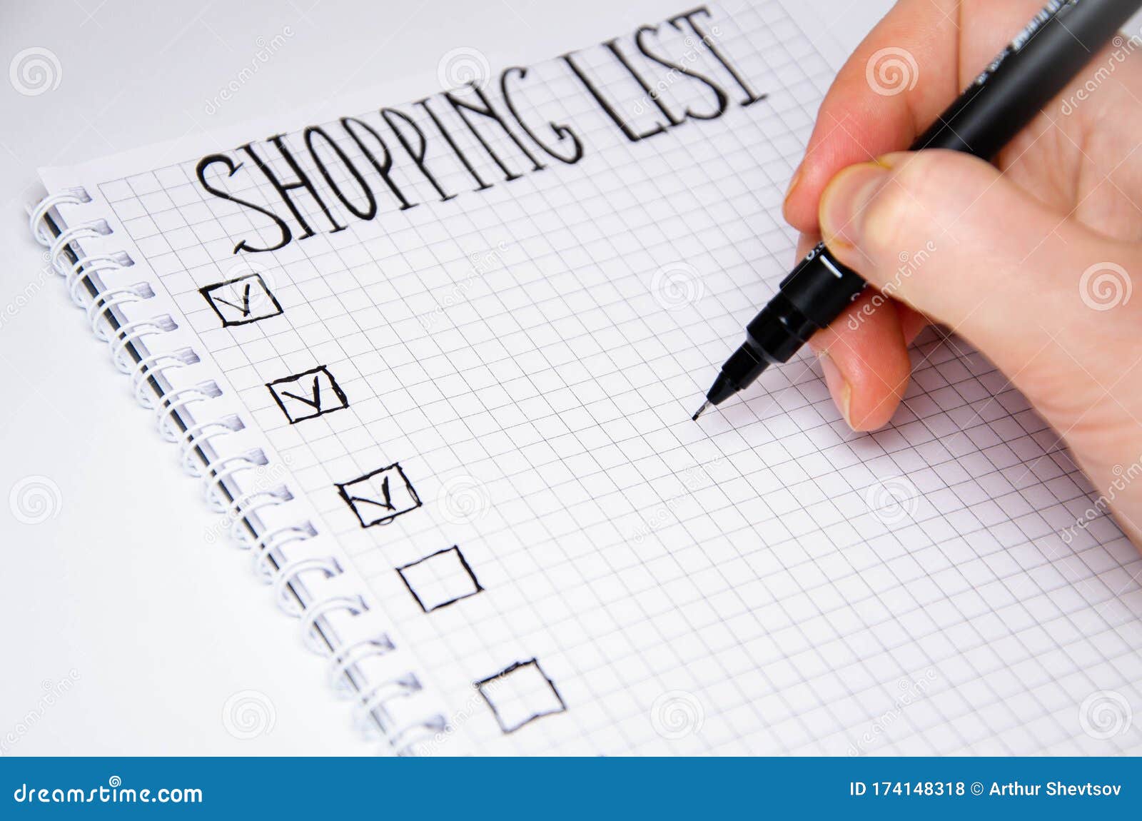 Shopping List. Hand Holds a Pen. Squared Notebook with Black Pen on a ...