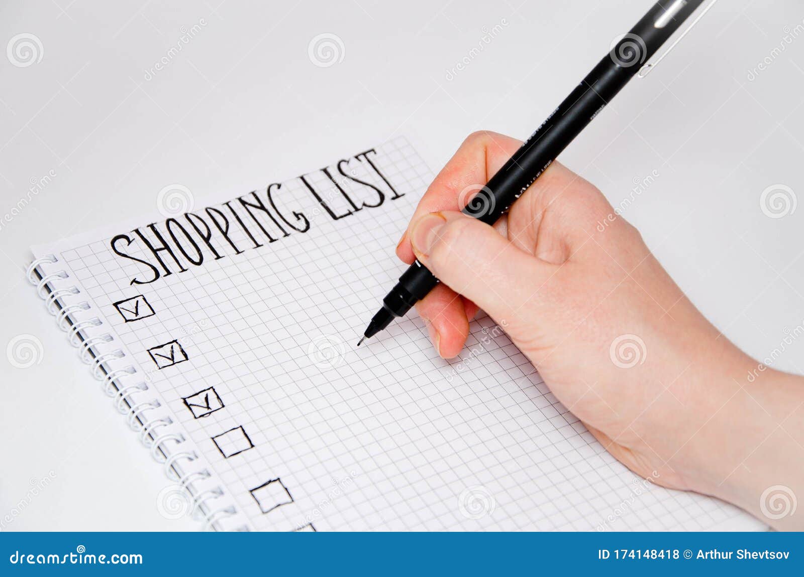 Shopping List. Hand Holds a Pen. Squared Notebook with Black Pen on a ...
