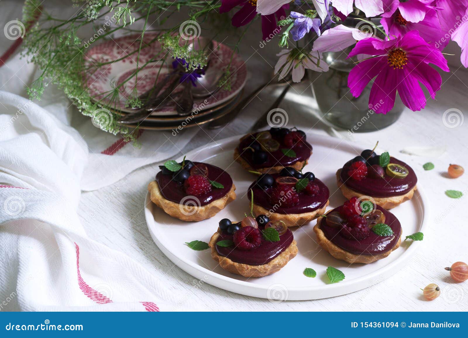 Shortbread Tartlets with Berry Custard and Flowers on a Light ...