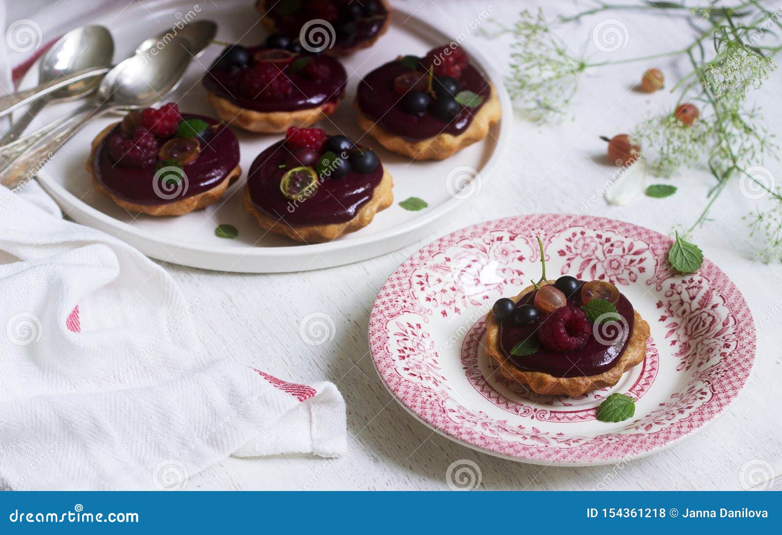 Shortbread Tartlets with Berry Custard and Flowers on a Light ...
