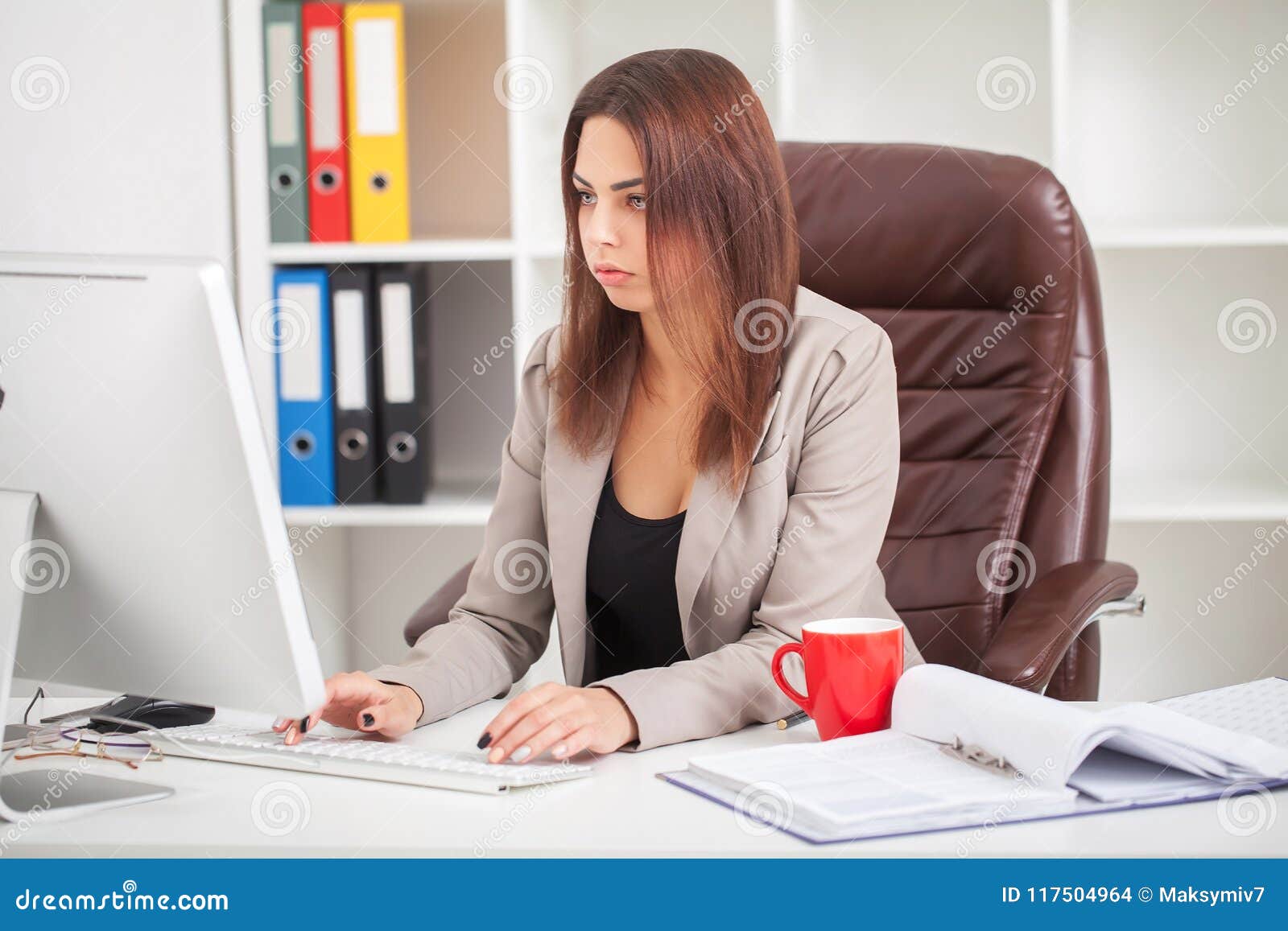 Shot Of Beautiful Young Woman Sitting At Her Work Desk Going Through