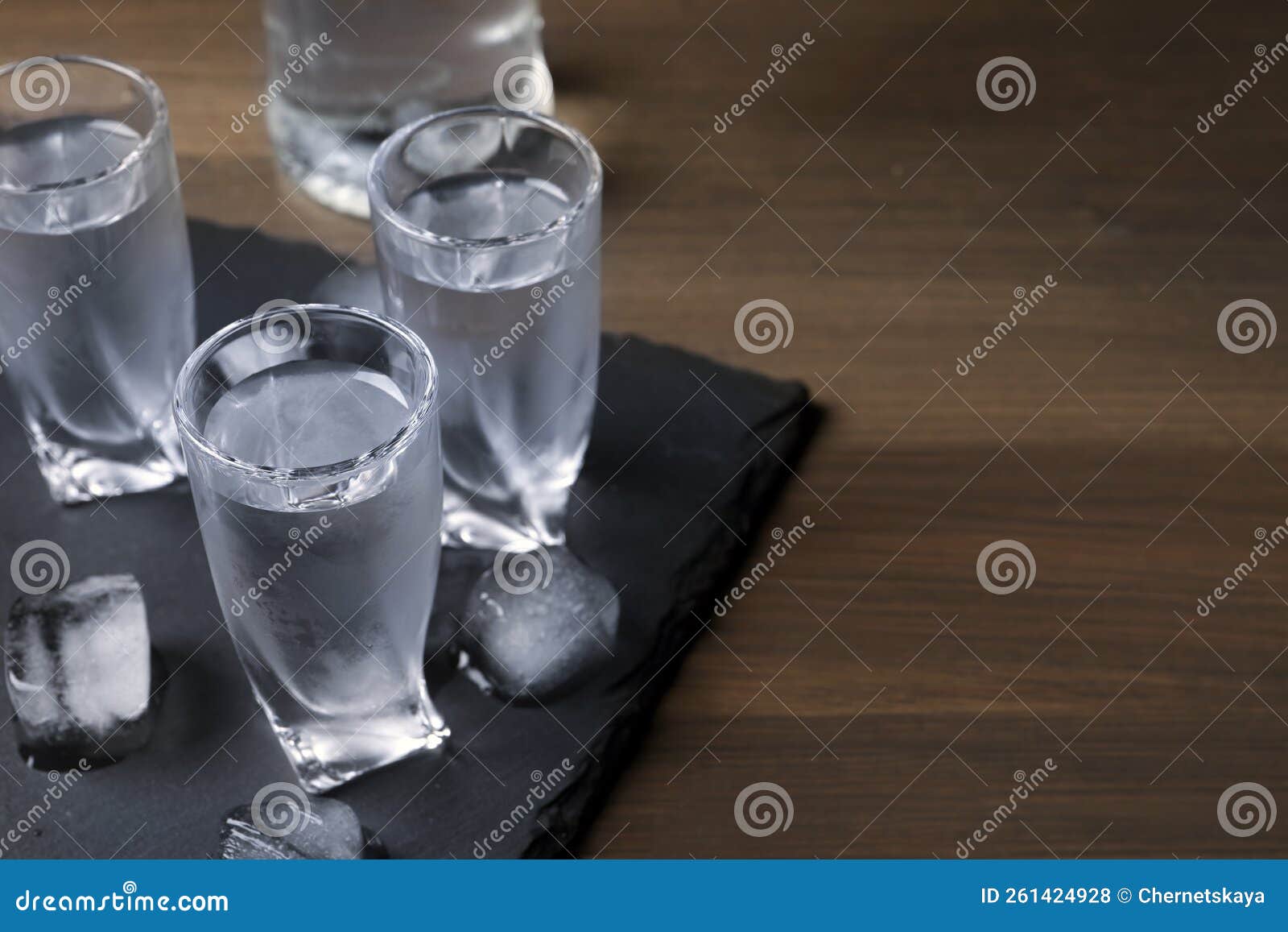 Shot Glasses of Vodka with Ice Cubes on Wooden Table. Space for Text ...