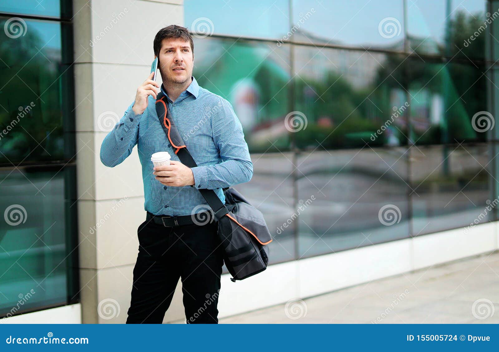 Shot of a Handsome Commuter Taking a Phone Call while Walking Outside ...