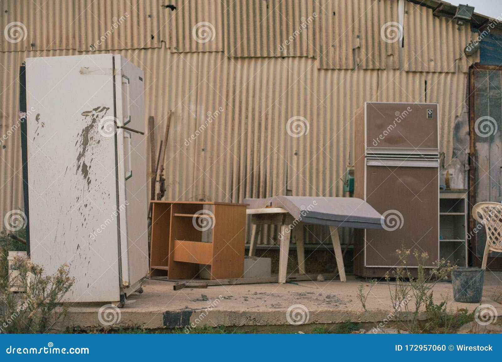Shot of Old and Rusty Fridges and Interior Objects Outdoors in Front of ...